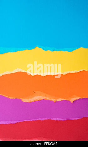 Ripped up pieces of coloured paper with copy space on cardboard ...