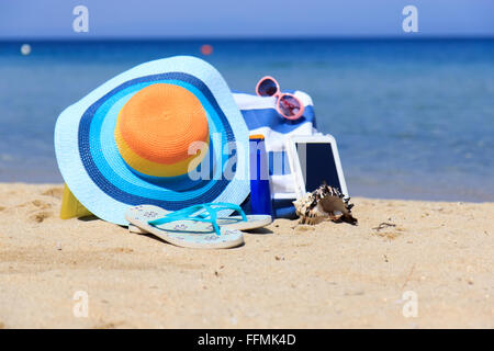 Beach bag, sun hat, cosmetics, denim shorts, camera, seashells on old ...
