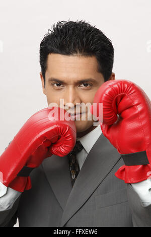 Young businessman employee wearing boxing gloves at workplace Stock ...