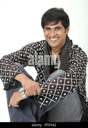 Handsome and fashionable indian man in black sitting at room, smoking ...