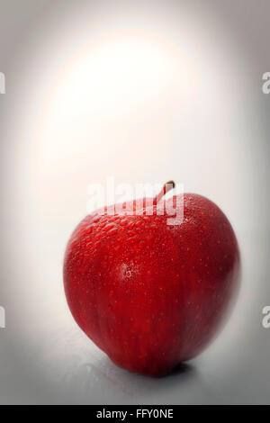 Red apple with water drops on a wooden kitchen table Stock Photo - Alamy