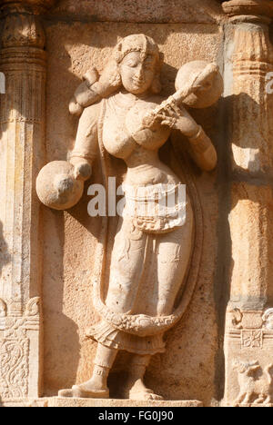 Richly carved statue of beautiful woman with musical instrument on wall ...