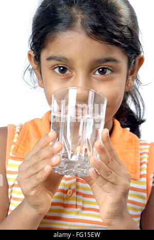Happy girl with glass of water looking at her friends by served table ...