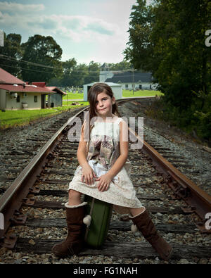 Girl sitting on railroad tracks Stock Photo - Alamy