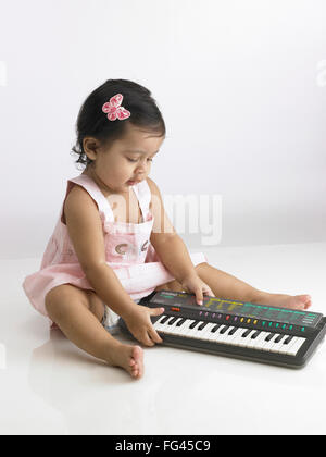 indian kids playing piano or keyboard, a musical instrument, isolated ...