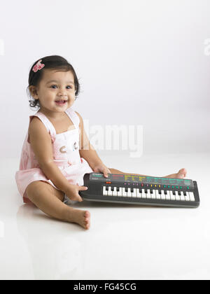 indian kids playing piano or keyboard, a musical instrument, isolated ...