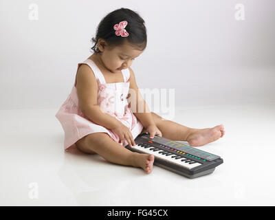 indian kids playing piano or keyboard, a musical instrument, isolated ...