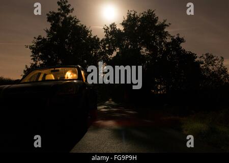 A man driving a car at night on a straight road Stock Photo - Alamy