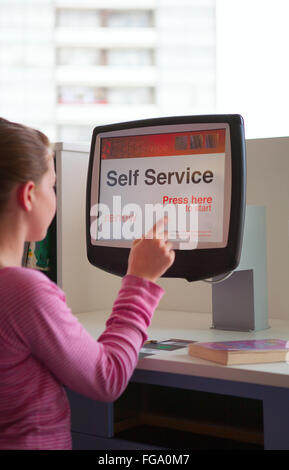 Young Girl Uses Self Service Library terminal to return books Stock ...