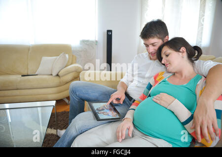 pregnant couple at home using tablet computer Stock Photo - Alamy