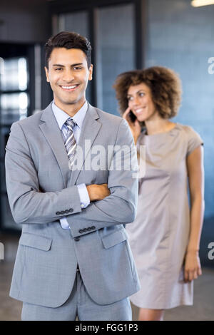 Good looking businessman posing at the office with crossed hands and ...