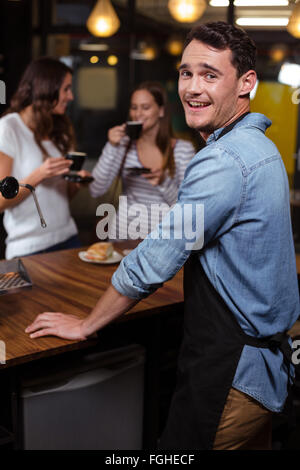 Smiling barista looking back at the camera Stock Photo - Alamy