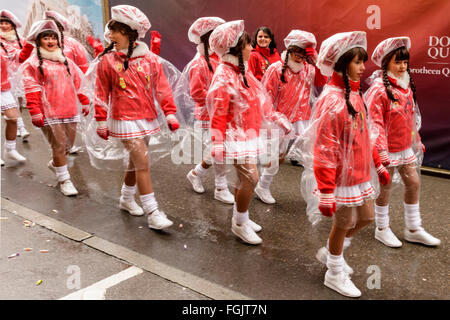 majorettes marching wrapped up against rain at Carnival parade ...