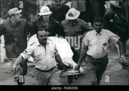 A black historic racing car is pushed by a man at a classic car event ...