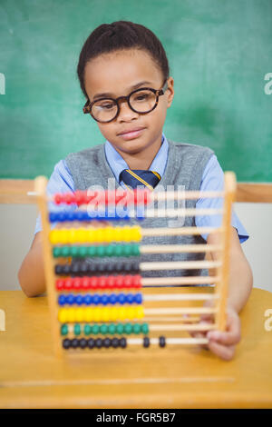 Cute pupil using abacus in classroom Stock Photo - Alamy