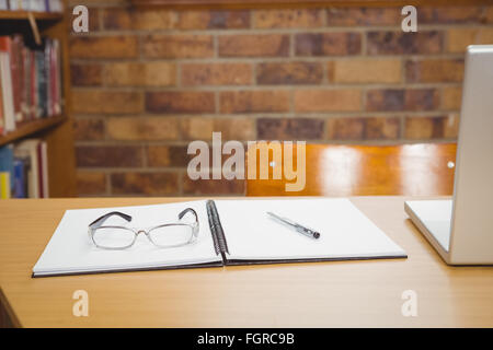 Desk with laptop, glasses and ledger on it Stock Photo - Alamy