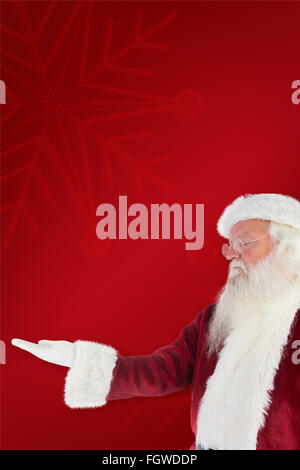 Composite image of santa shows something to camera Stock Photo - Alamy