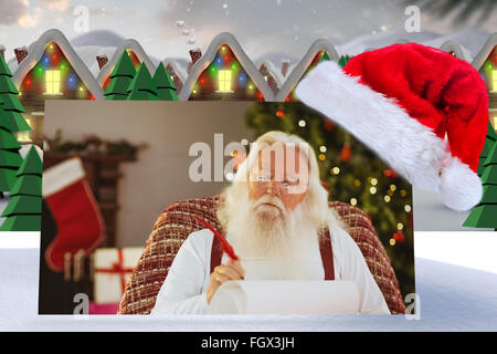 Composite image of relaxed santa writing list with a quill Stock Photo ...