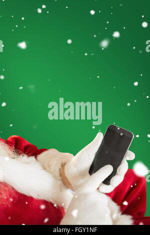 Composite image of santa using smartphone Stock Photo - Alamy