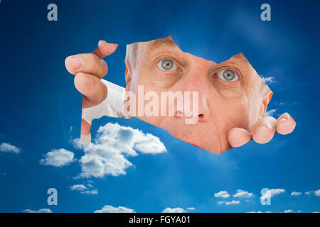 Older man looking through rip Stock Photo - Alamy