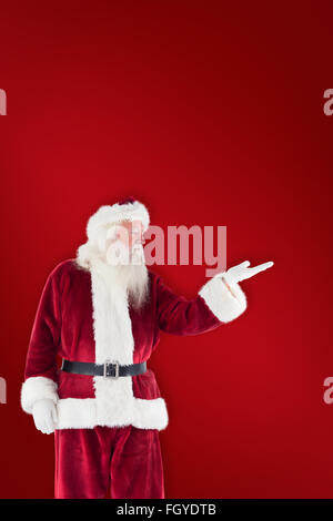 Composite image of santa shows something to camera Stock Photo - Alamy