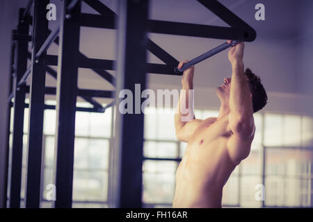 Muscular man lifting himself up and down Stock Photo - Alamy