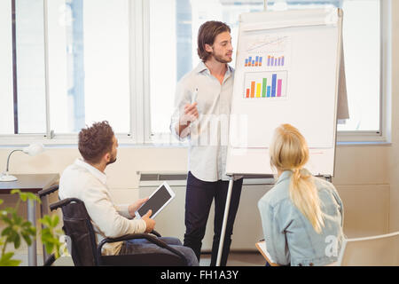 Businessman explaining multi colored graph Stock Photo - Alamy