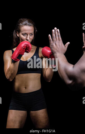 Female boxer with fighting stance against trainer hand Stock Photo - Alamy