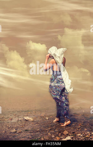 Woman struggling against strong wind, holding on to leaning tree Stock ...