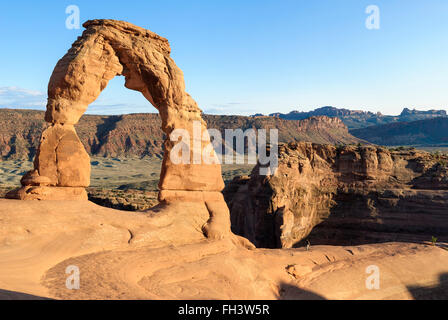 A tourist walks towards Delicate Arch in Arches national Park, Utah ...