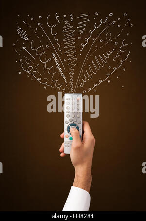 Hand with remote control and curly lines Stock Photo - Alamy