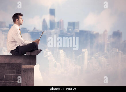 Sales person sitting on top of a tall building Stock Photo - Alamy