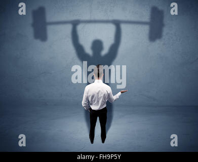 Businessman with weight lifting shadow Stock Photo - Alamy