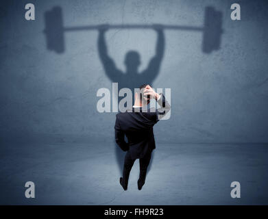 Businessman with weight lifting shadow Stock Photo - Alamy