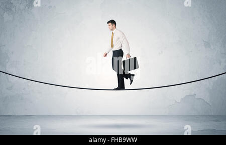 Sales guy balancing on tight rope Stock Photo - Alamy