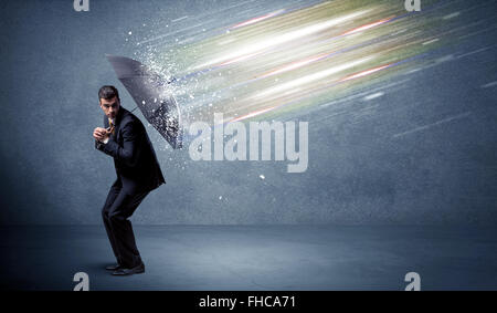 Business man defending light beams with umbrella concept Stock Photo ...
