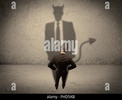 Salesman facing his own devil shadow Stock Photo - Alamy