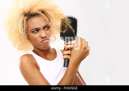 Dark skinned young woman combs her hair brush. Tangled hair. Combing ...