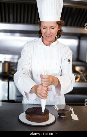 Female chef icing a cake Stock Photo - Alamy