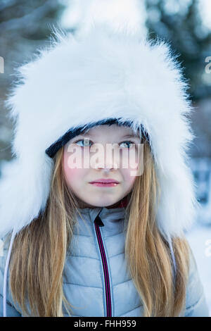 Portrait of a girl in winter clothes. In the winter park. Face close-up ...
