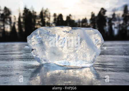 a chunk of ice with frozen bubbles in the water. a small iceberg in the ...