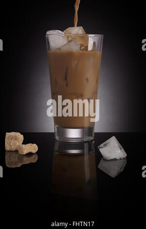 Delicious ice coffee with melting ice cubes and brown sugar on dark ...
