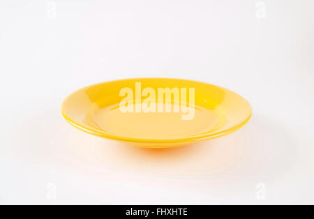 empty yellow plate on white background Stock Photo - Alamy