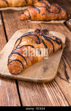 Fresh made Chocolate Croissants (close-up shot) on wooden background ...