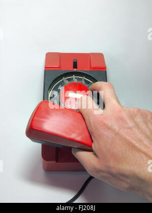Dialing Using rotary Disk on A vintage Orange color Rotary Phone. Land ...