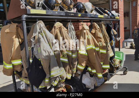 firefighters turnout gear hanging on racks Stock Photo - Alamy