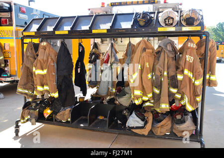firefighters turnout gear hanging on a wall in a firehouse in ...