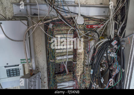 A telephone distribution board in an old office block with parts ripped ...