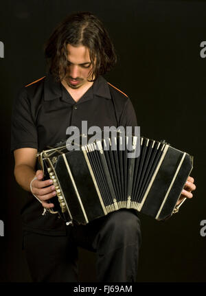 Young man playing the bandoneon in milonga, party where you only dance ...