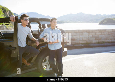 Happy young Chinese men and jeep Stock Photo - Alamy